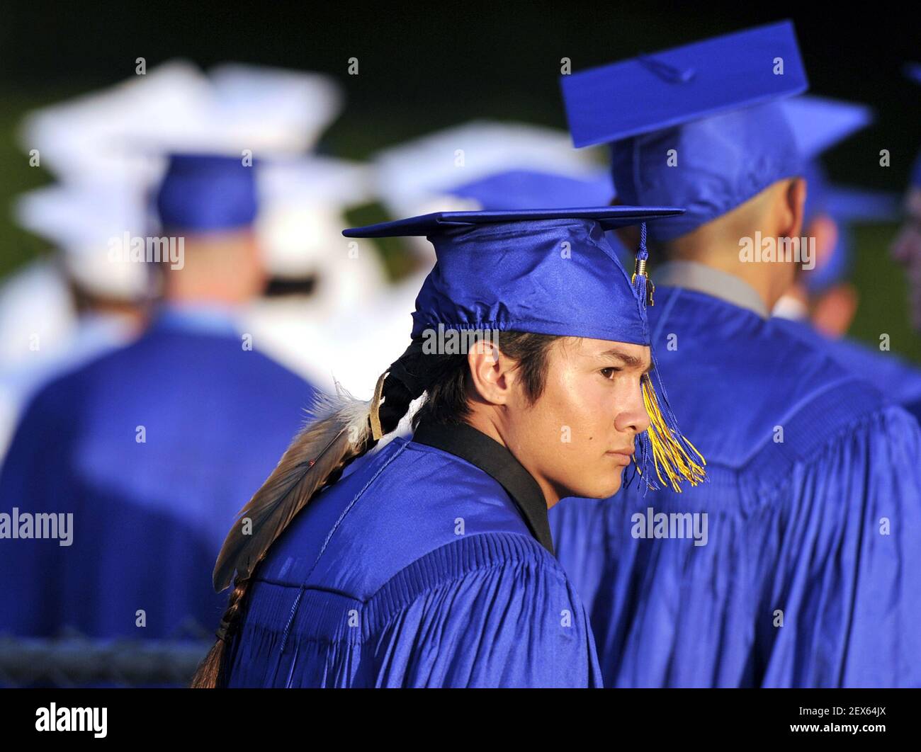Christian Titman, center, looks into the sun wearing a feather as he ...