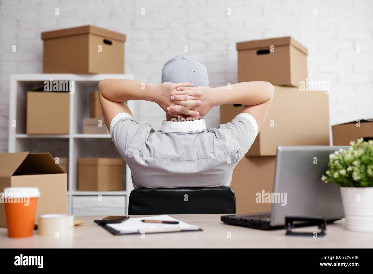 Back view of postman or loader resting in post office or warehouse ...