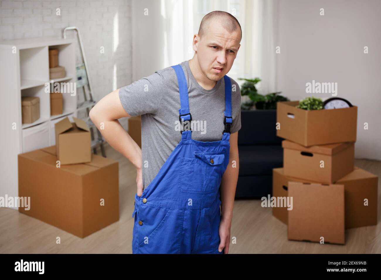 hard work and health problems concept - loader suffering from back pain ...