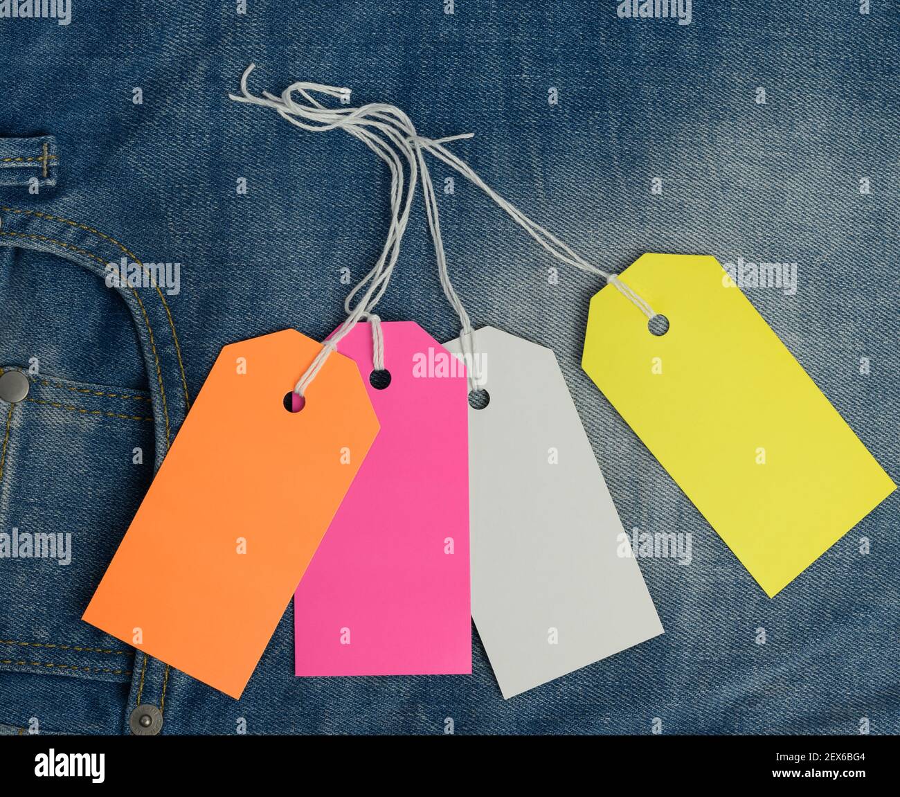 blank rectangular cardboard colored tags on blue jeans background, top ...