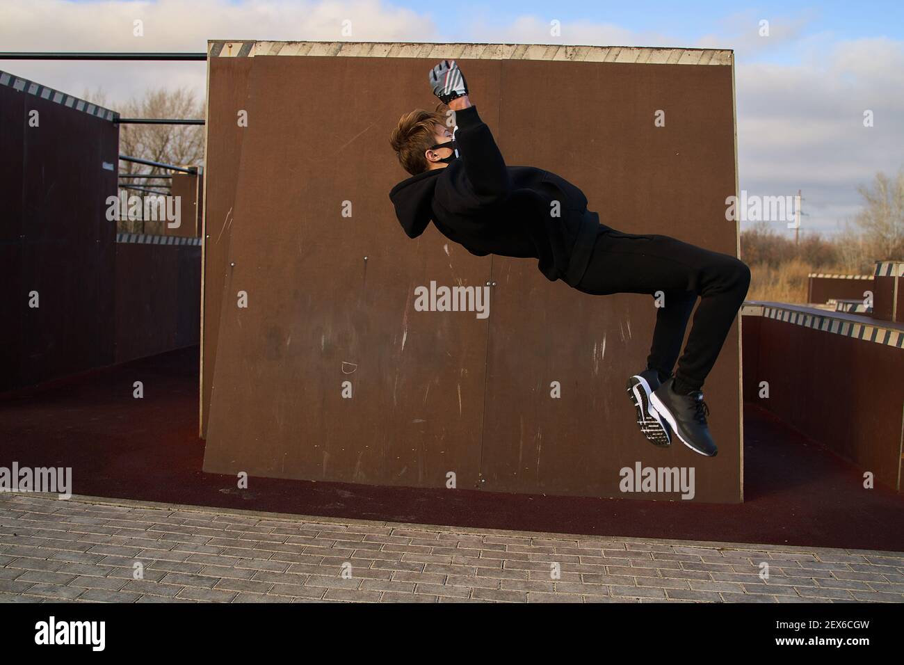 Young guy doing back flips on street sports ground for cross fit. High ...