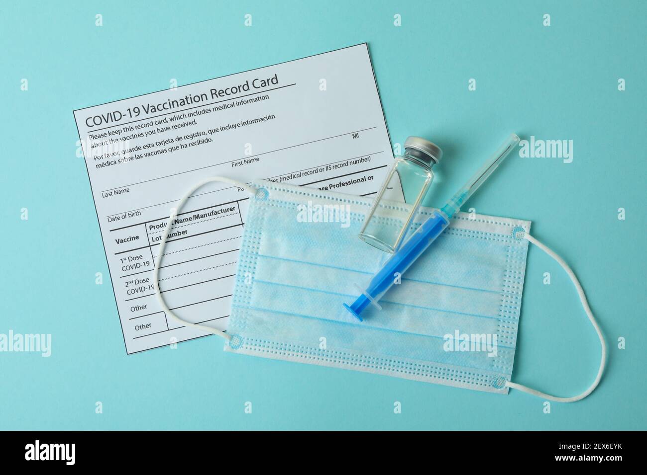 Vaccination record card, mask and syringe on blue background Stock ...