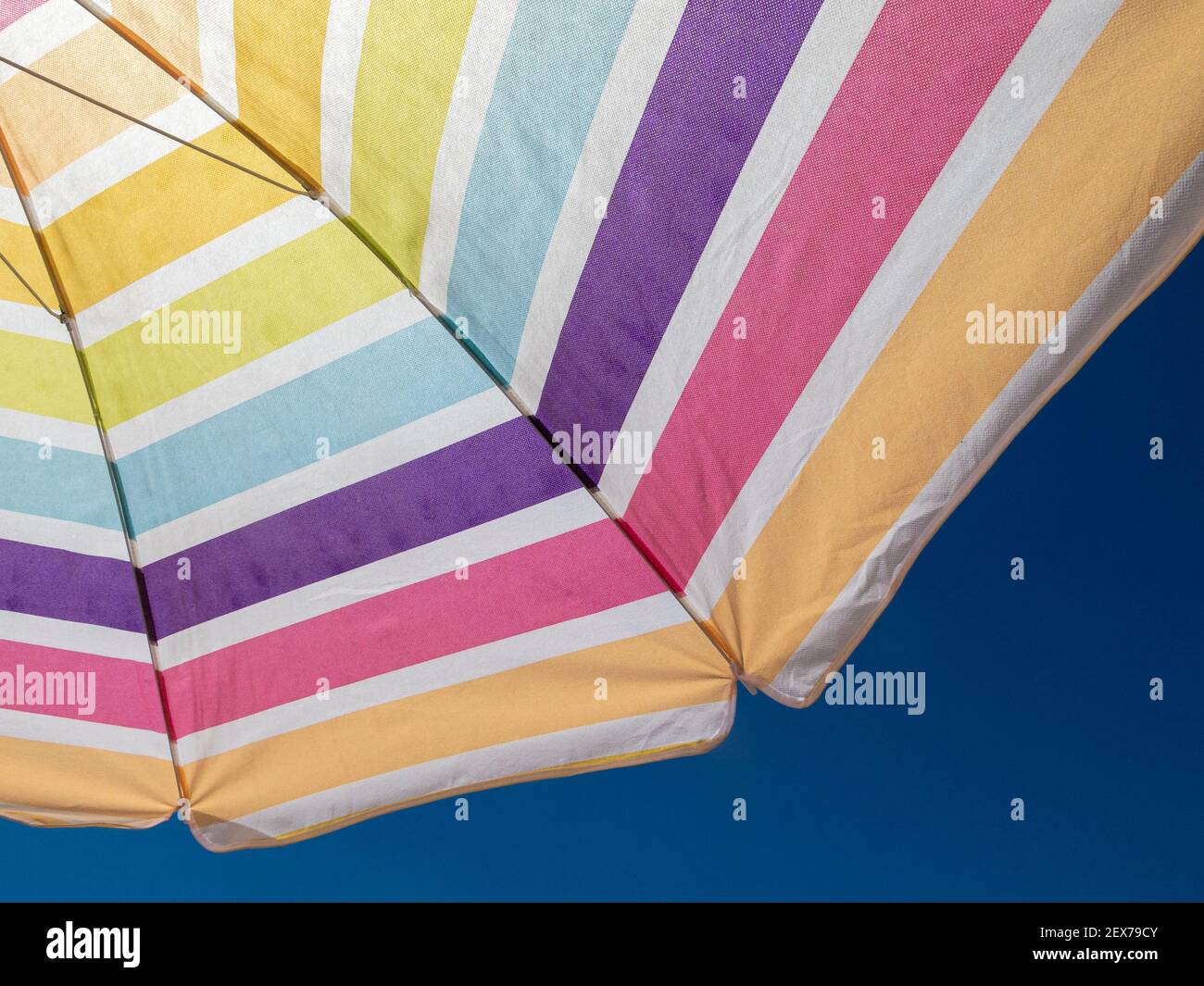 beach umbrella in the summer of spain with multi coloredin a blue sky ...