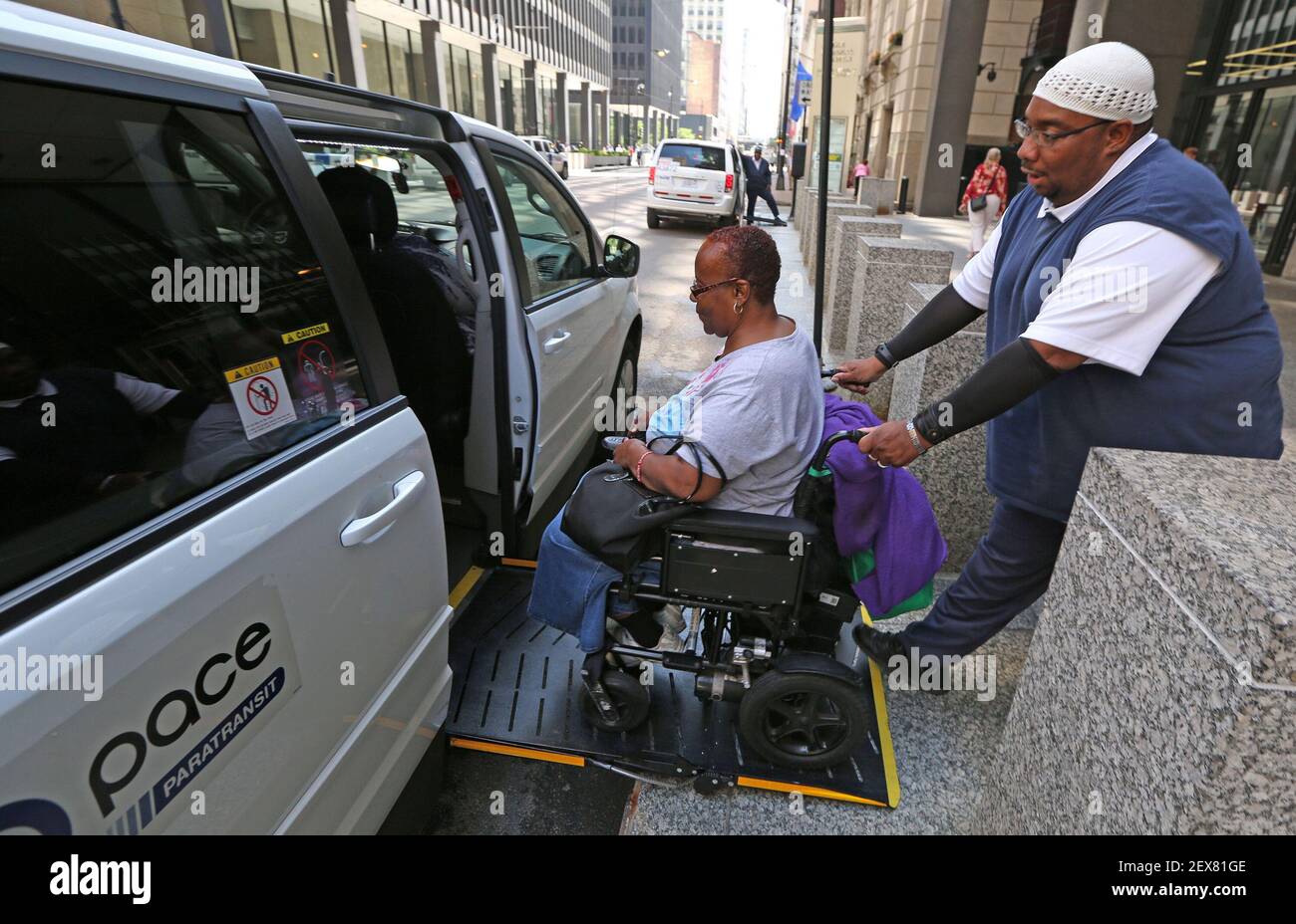 Pace driver Carl James assists Renita Freeman into his van as she ...
