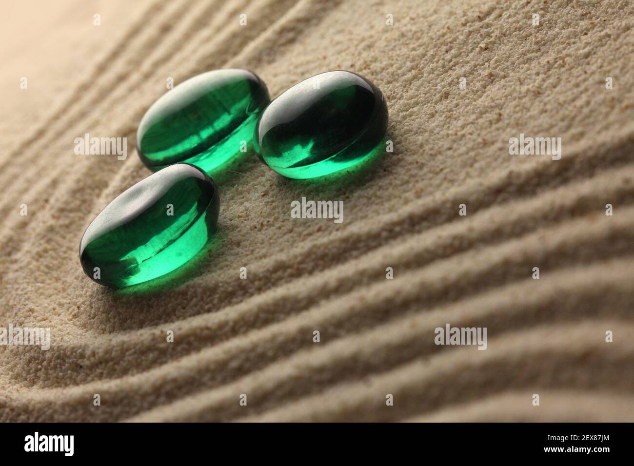 Green stones on a sand Stock Photo - Alamy