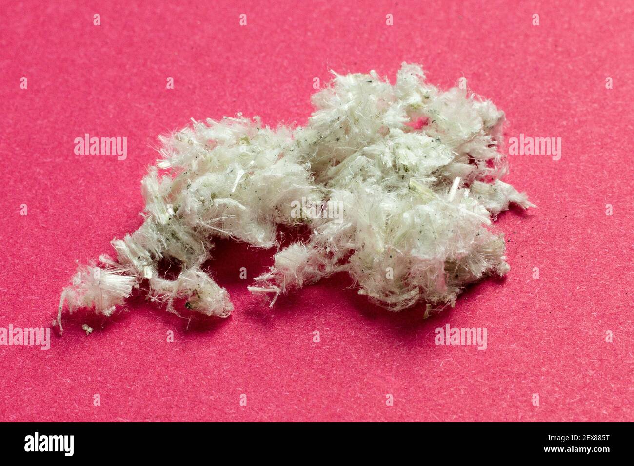 Hazardous mineral asbestos close up on red background Stock Photo - Alamy
