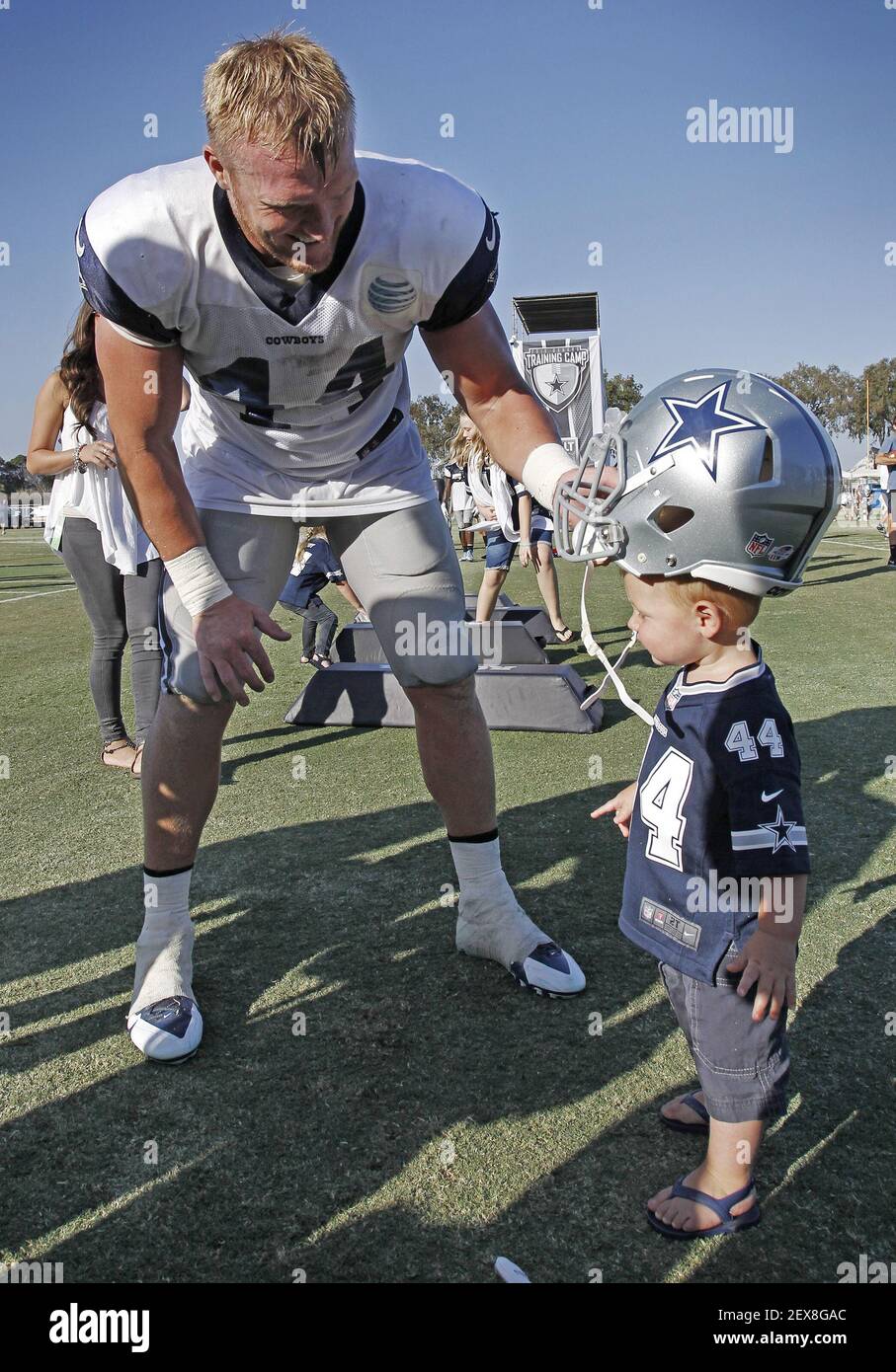 Dallas Cowboys fullback Tyler Clutts (44) puts his helmet on a smaller ...