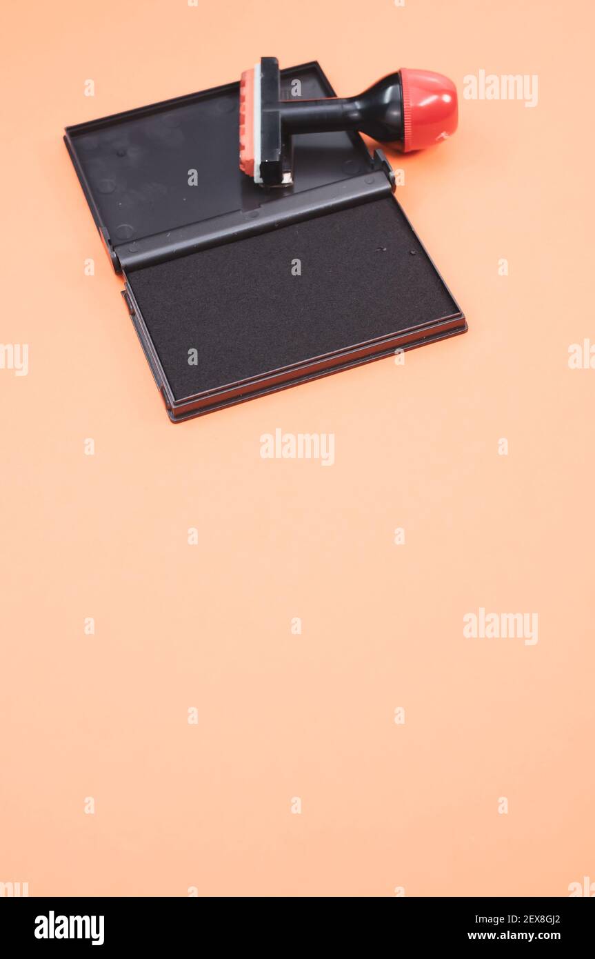 The black ink pad with a rubber stamp isolated on orangbackground Stock ...