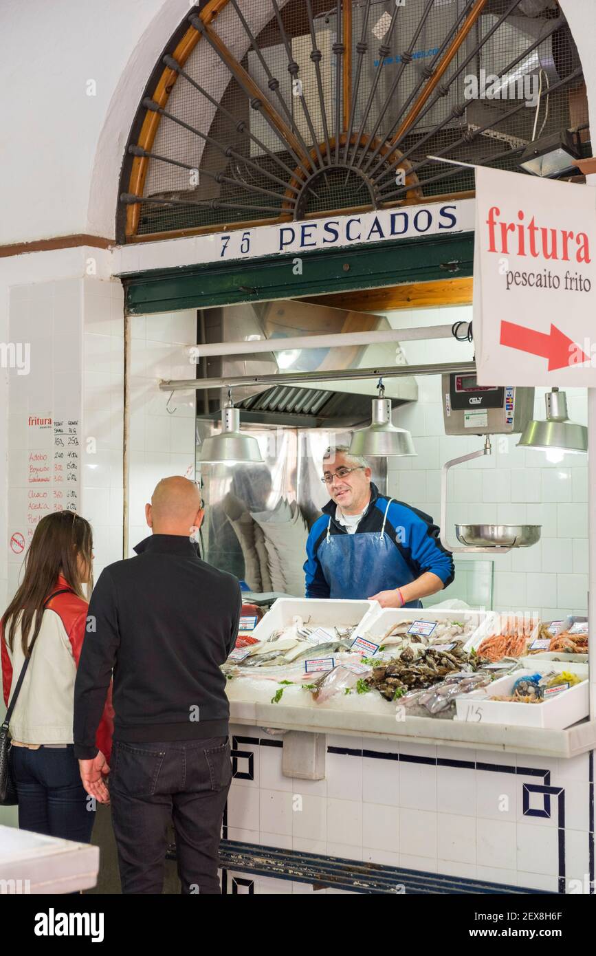 People buying fish from a market stall fishmongers in Triana Market ...