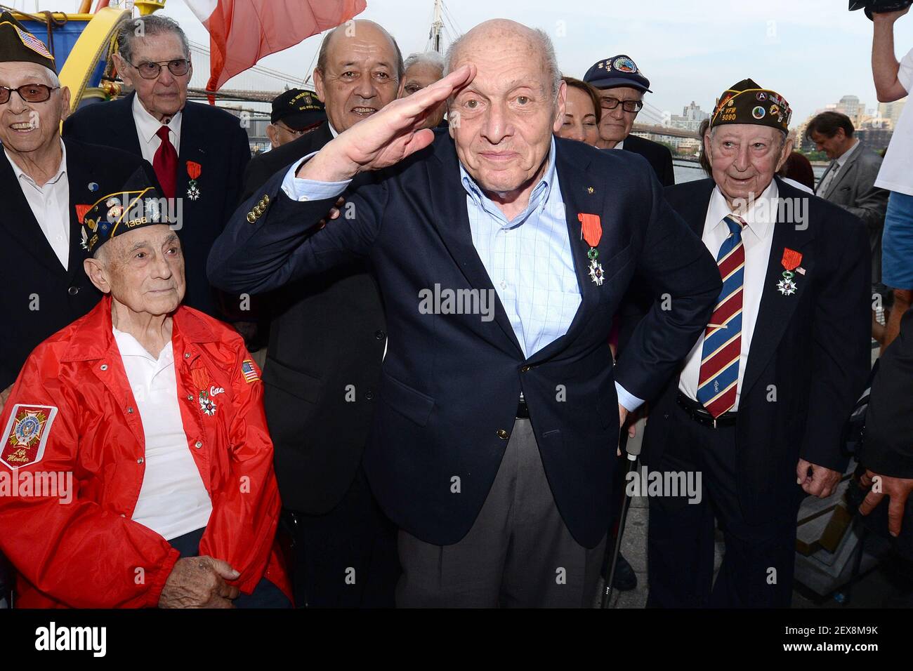Harry Ettlinger (blue shirt, no tie) salutes as he poses for a photo in ...