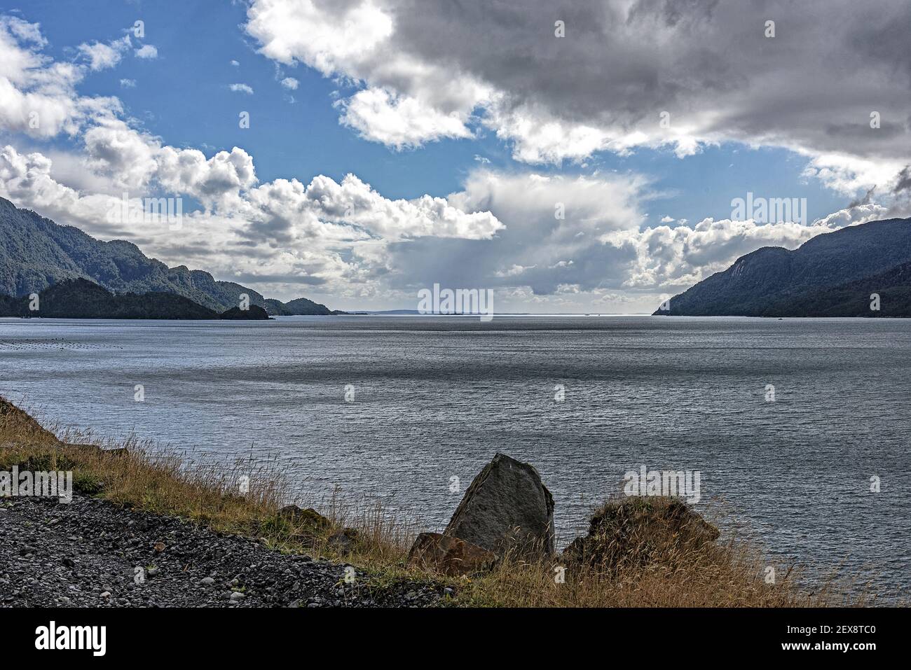 A beautiful view of the flowing river surrounded by mountains gleaming ...