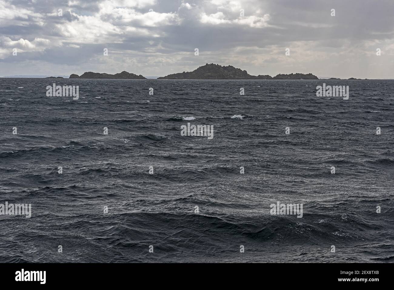 The beautiful and wavy ocean gleaming under the cloudy and rainy sky on ...