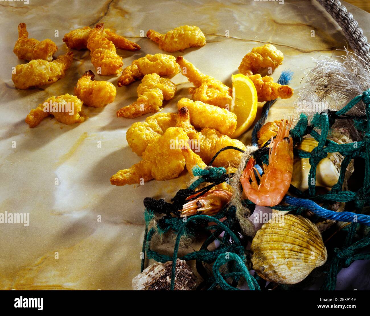 Cooked Scampi and prawns on a marble background with fishing net and ...