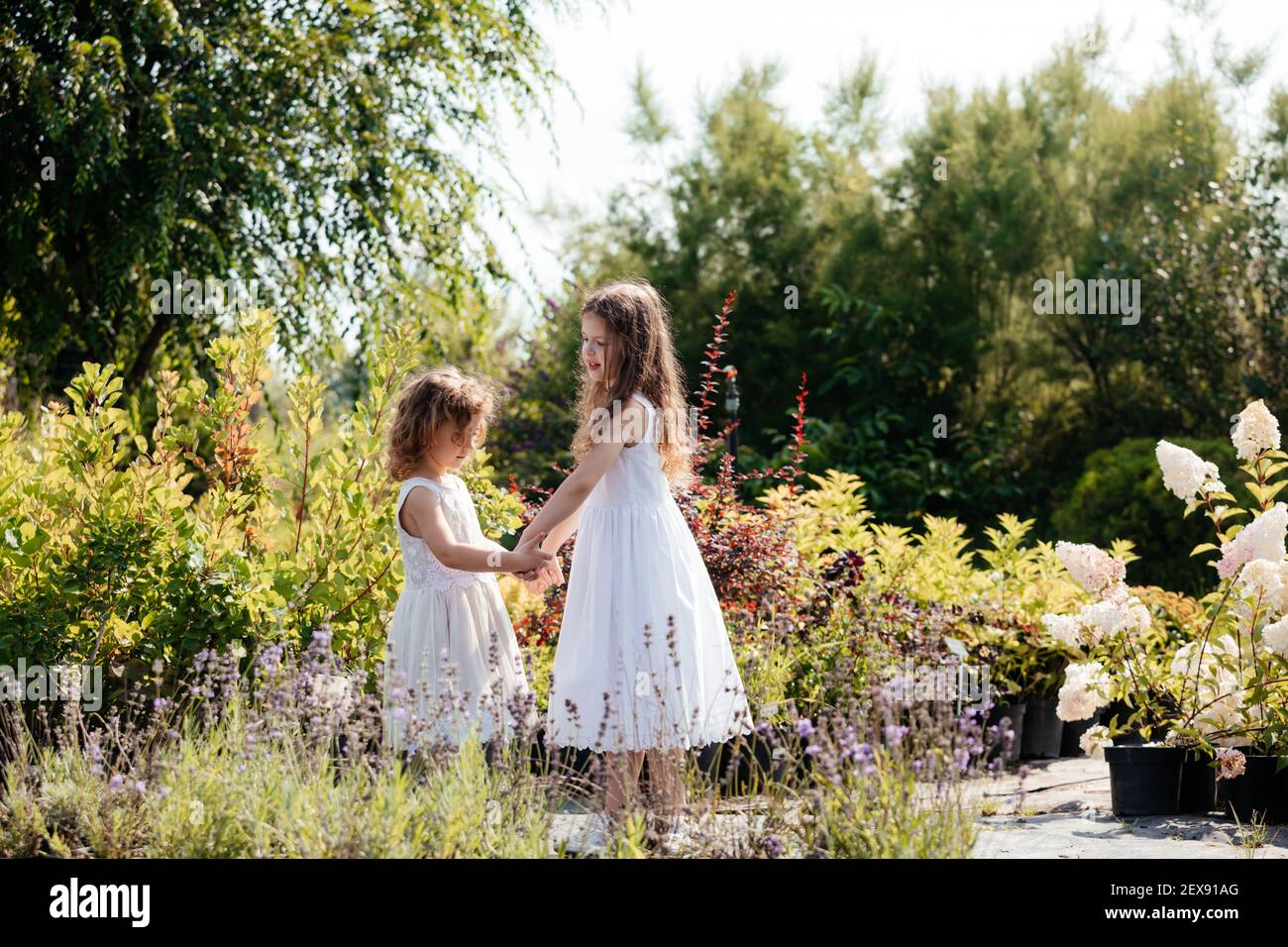 Little girls dancing among wonderful blooming flowers Stock Photo - Alamy