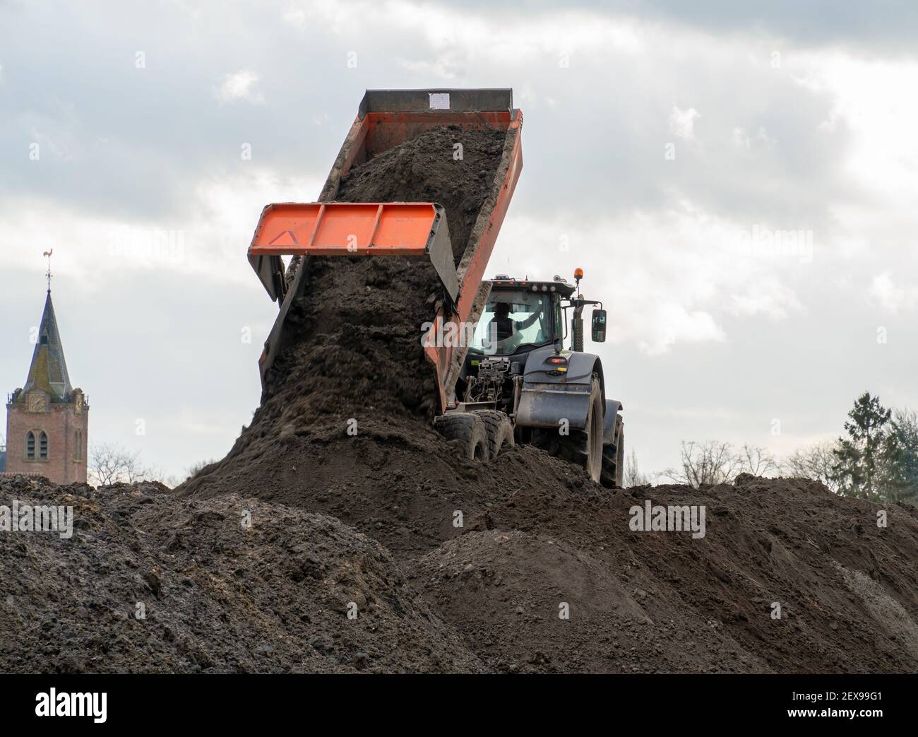Scene with tractor dumping soil Stock Photo - Alamy