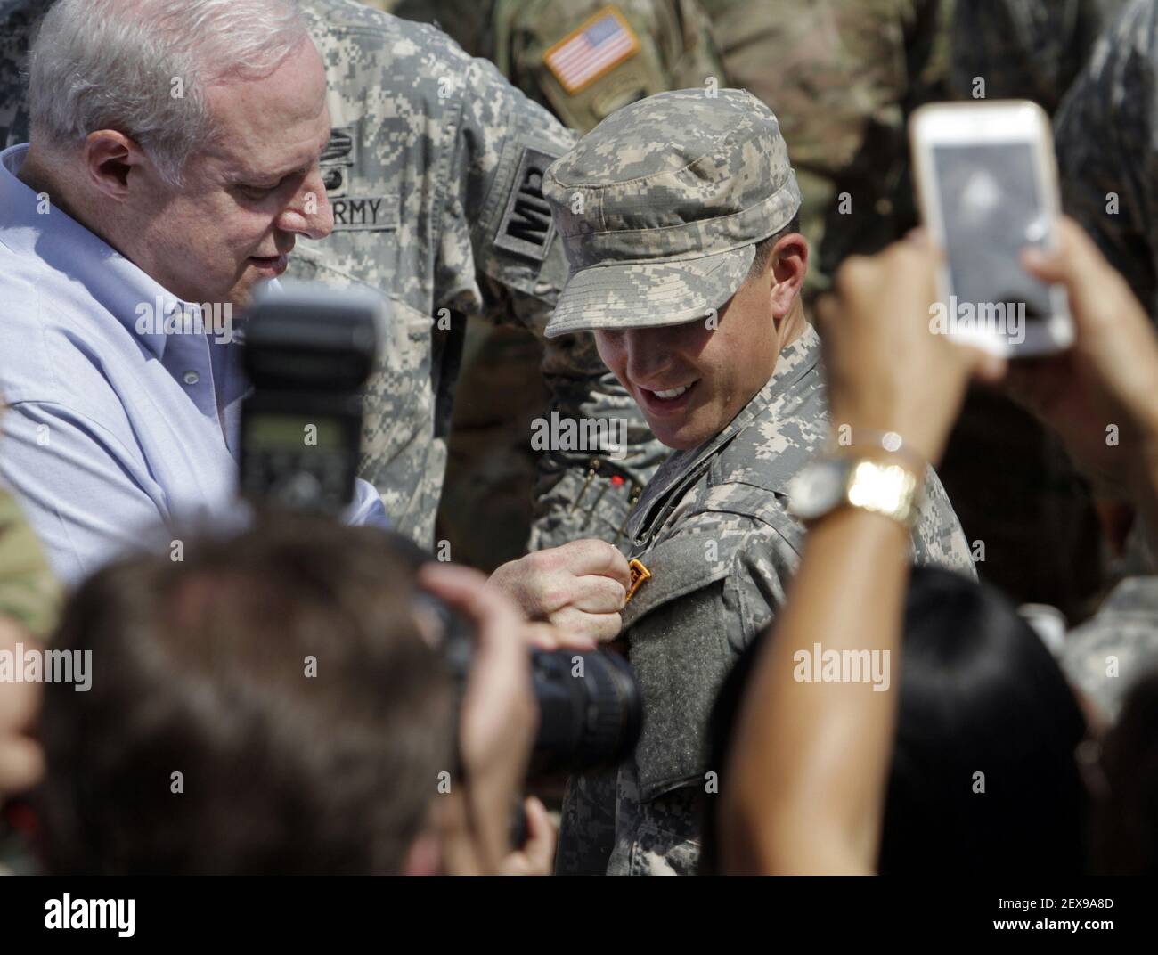 Capt. Kristen Griest smiles as her father pins the Ranger tab to her ...