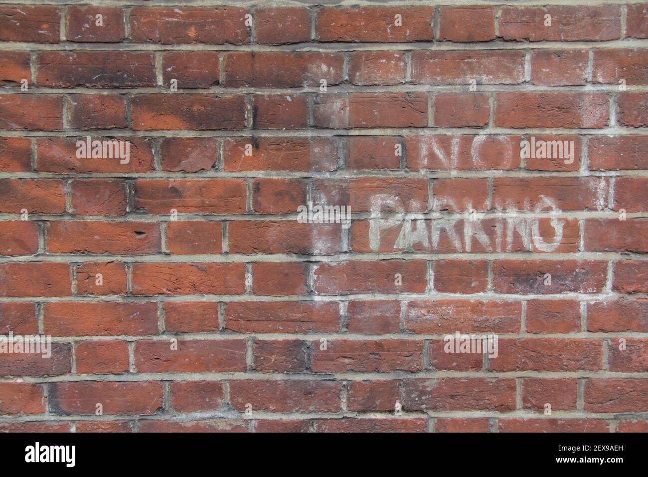 Painted No Parking Sign on the Red Brick Wall Stock Photo - Alamy