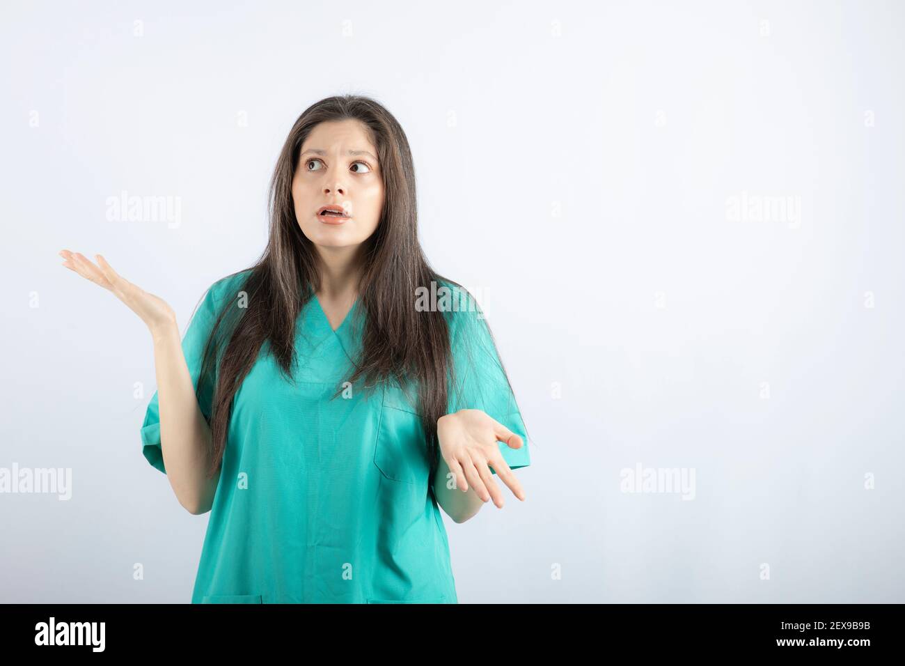 Shocked and scared young nurse on white background Stock Photo - Alamy