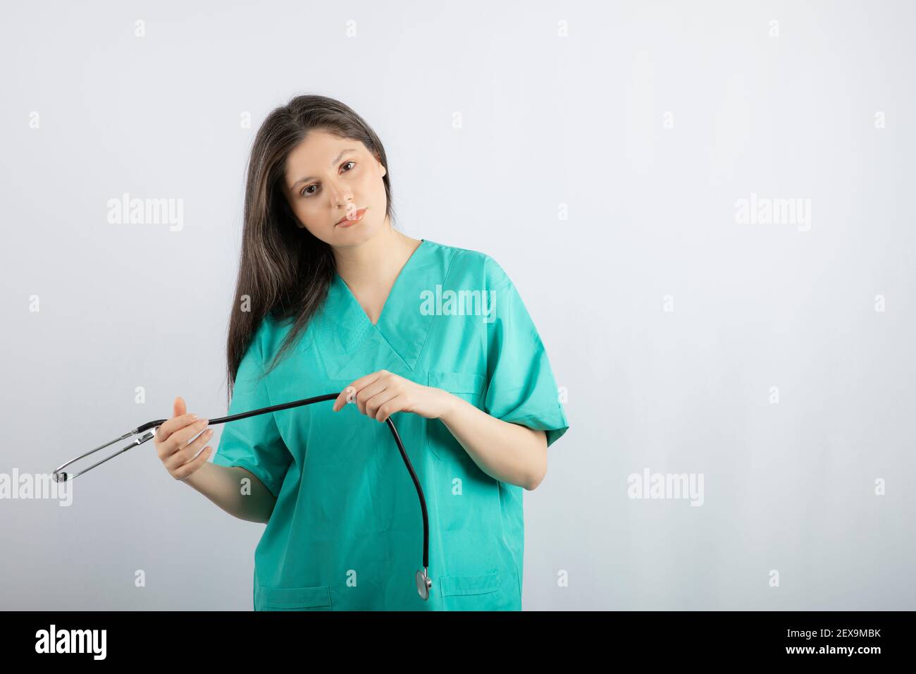 Young nurse playing with stethoscope and looking at camera Stock Photo ...