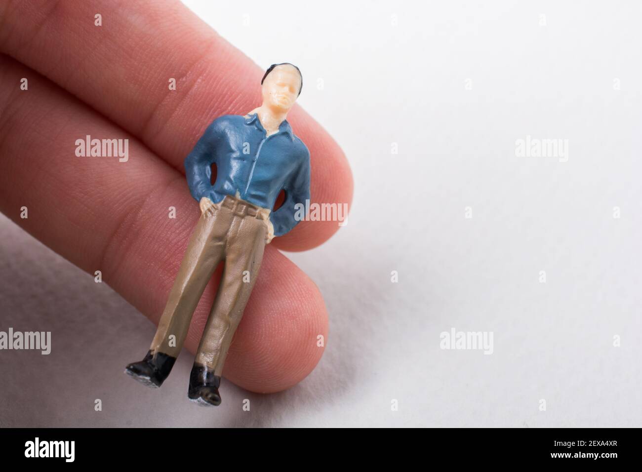 Tiny figurine of man miniature model in hand Stock Photo - Alamy