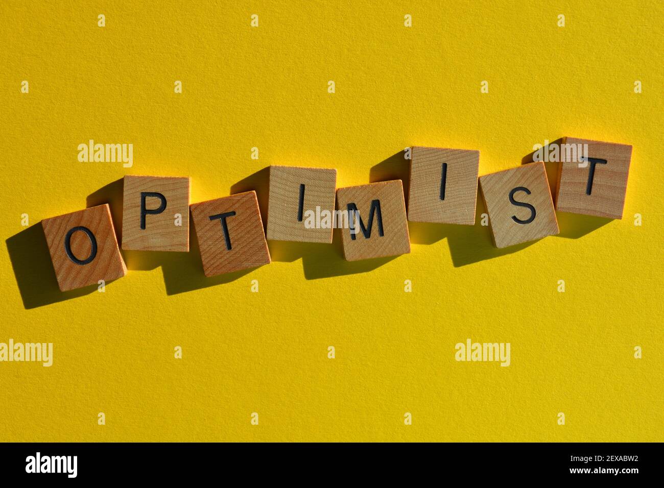 Optimist, word in wooden alphabet letters isolated on bright yellow ...