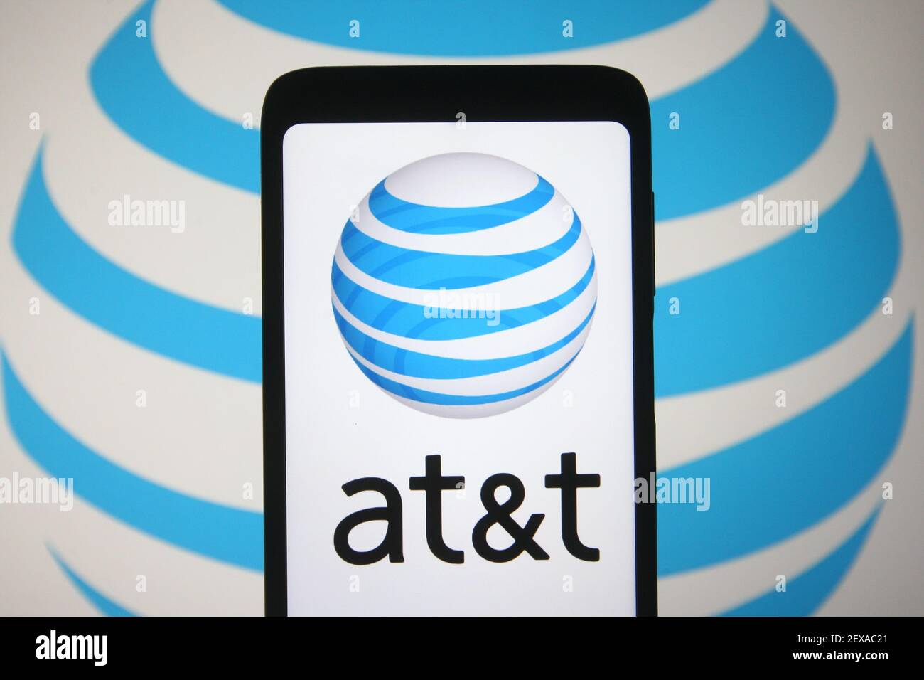 In this photo illustration the AT&T logo is seen on a smartphone and a ...