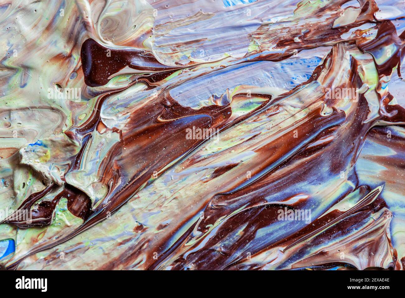 Colored strokes of acrylic paint on the artist's palette close-up ...