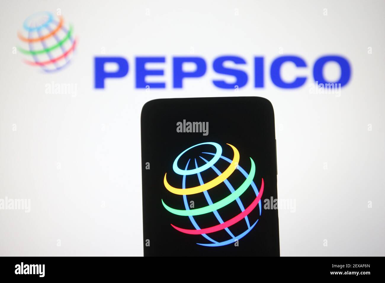 In this photo illustration a Pepsico logo is seen on a smartphone and a ...