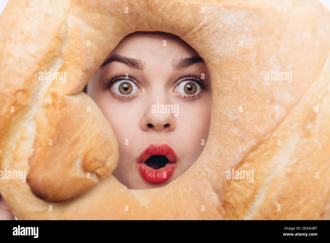 happy woman with round loaf of bread in front of face bright makeup ...