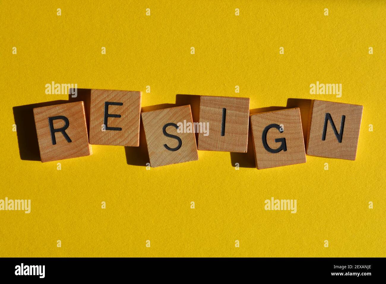 Resign, word in wooden alphabet letters isolated on yellow background ...