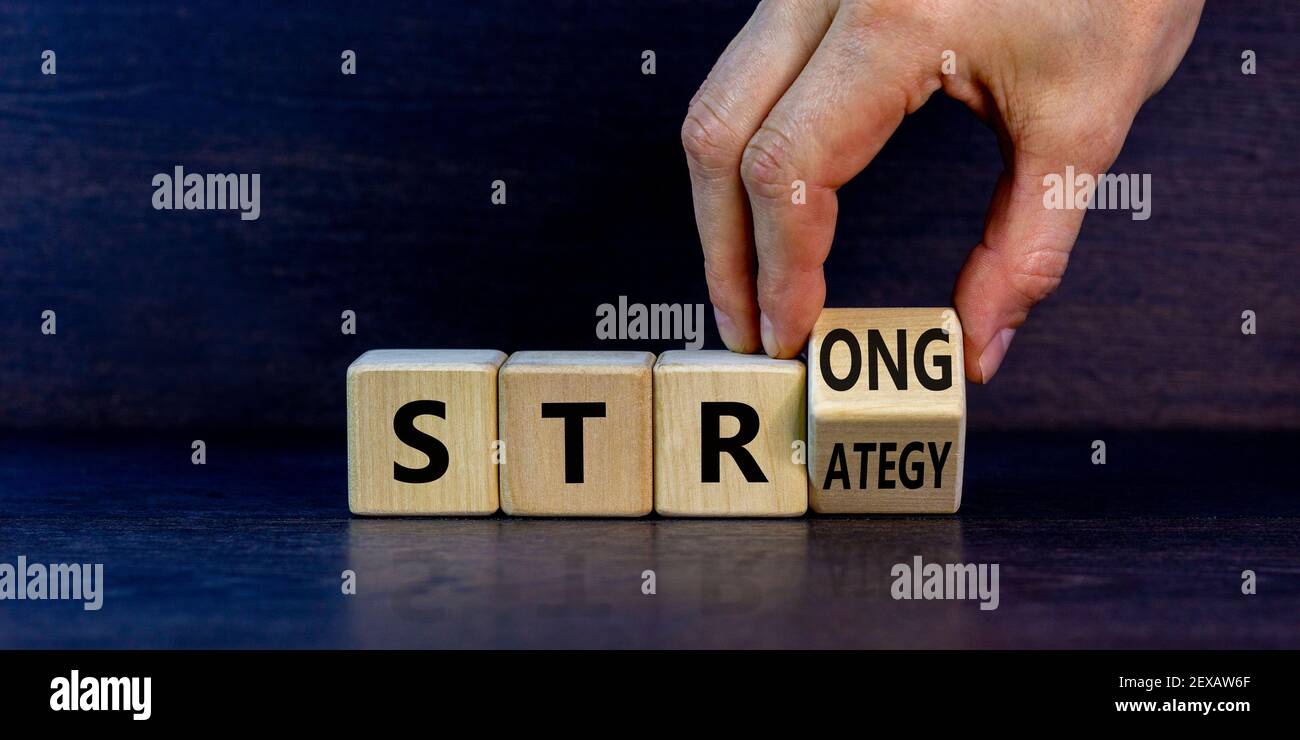 Strong strategy symbol. Businessman turns a wooden cube with words ...