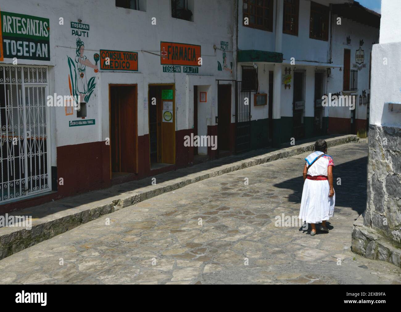 Indigenous Nahua woman walking on the narrow cobblestone streets with ...