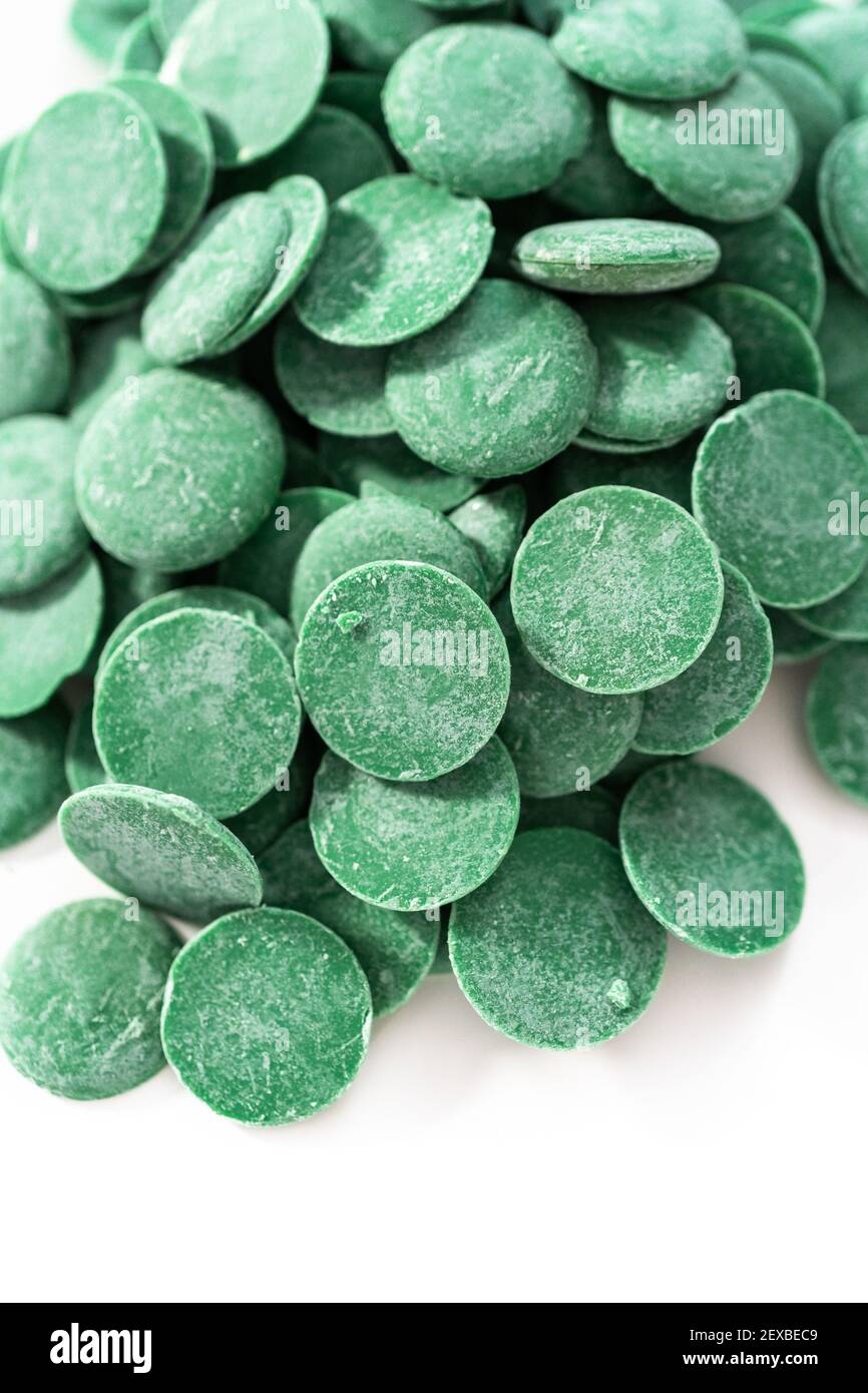 Green round chocolate chips for melting chocolate shapes on a white ...