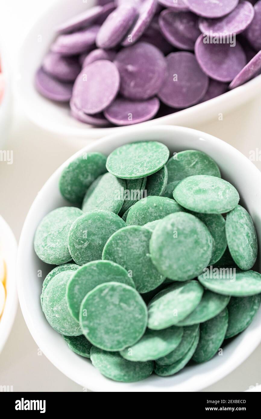 Rainbow colors of round chocolate chips in a white bowls for melting ...