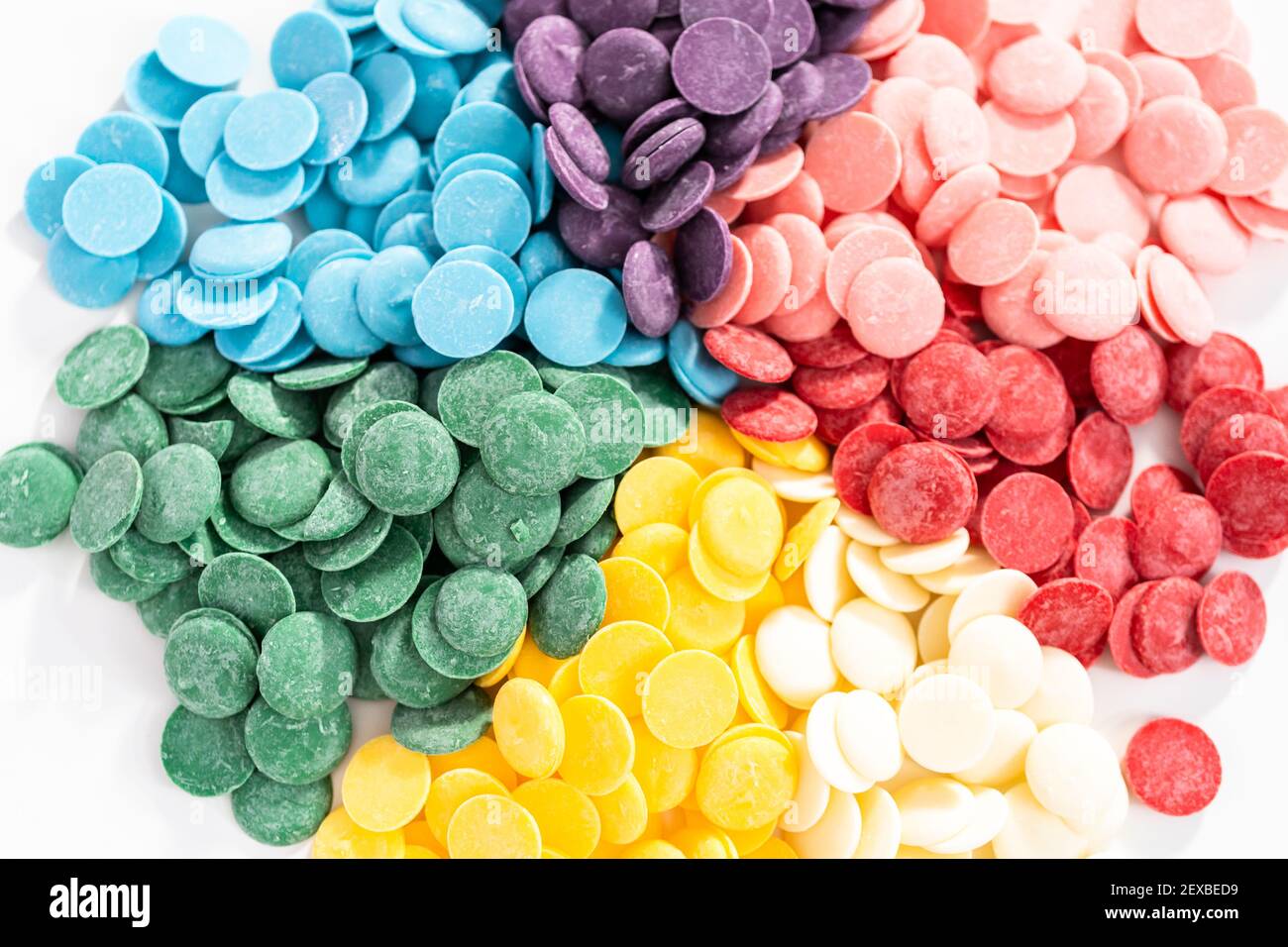 Rainbow colors of round chocolate chips for melting chocolate shapes on ...