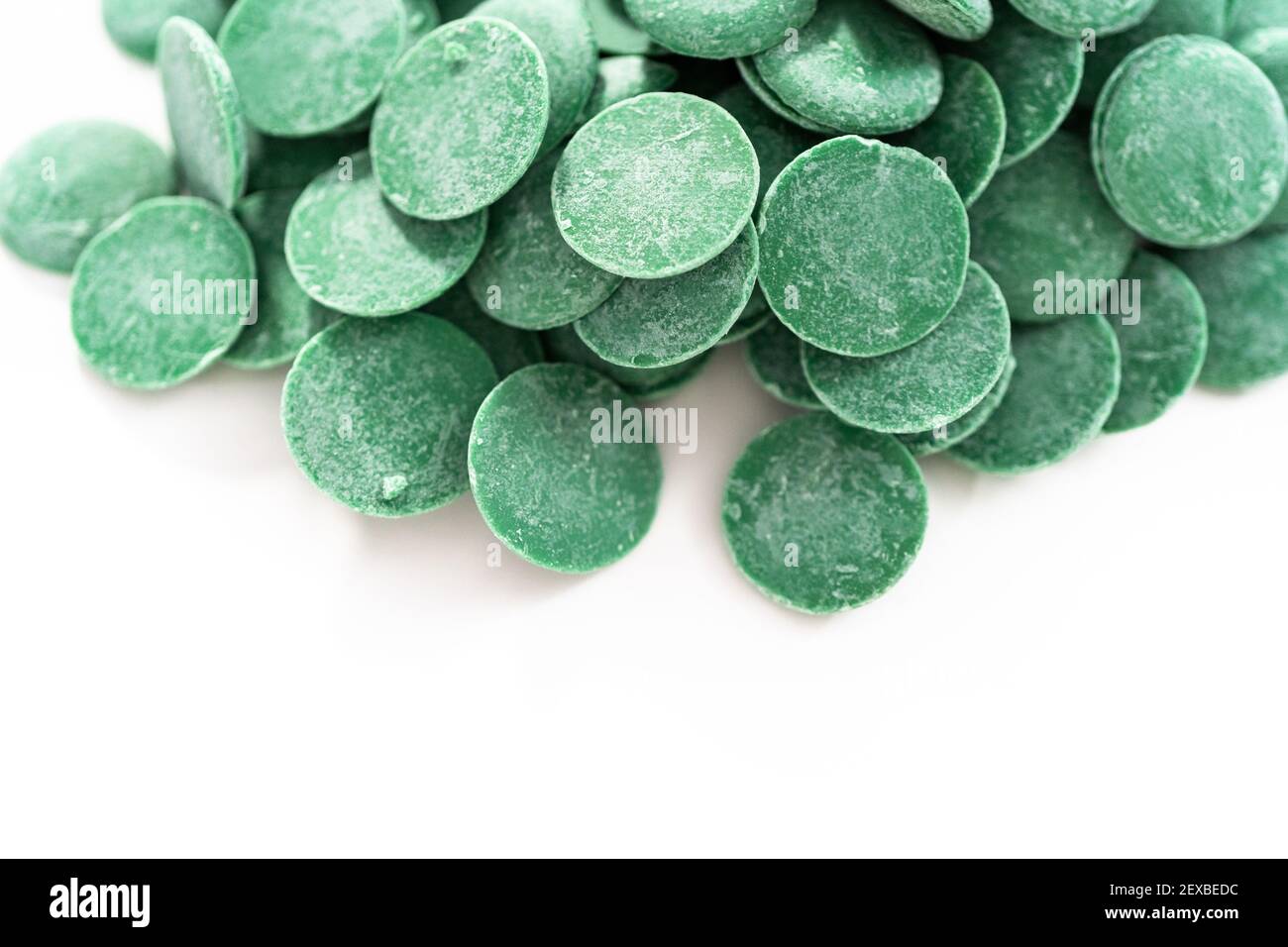 Green round chocolate chips for melting chocolate shapes on a white ...