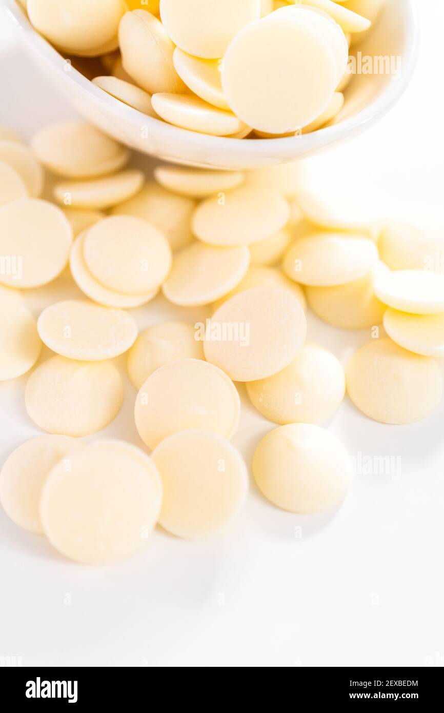 White round chocolate chips for melting chocolate shapes on a white ...
