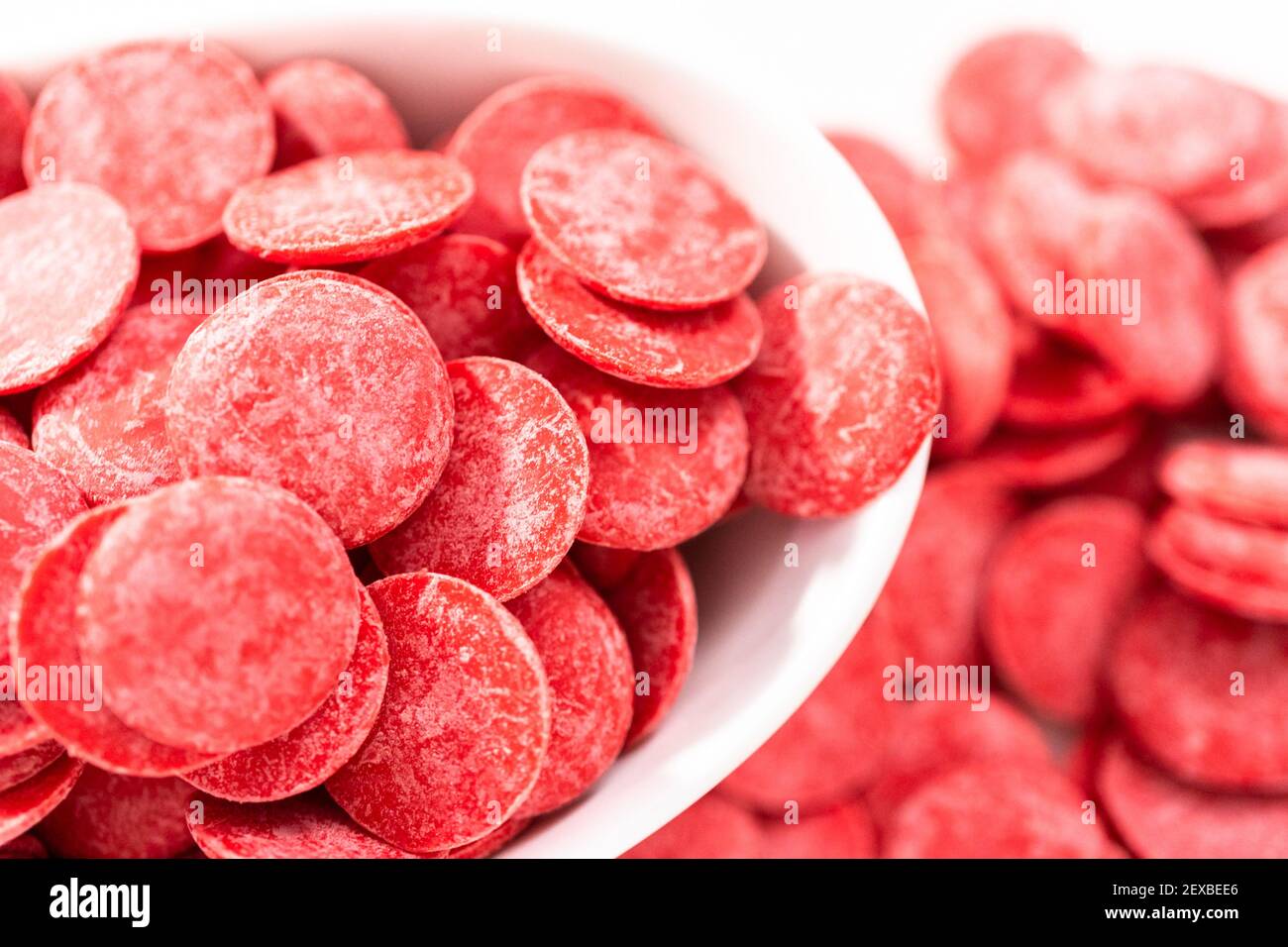 Red round chocolate chips for melting chocolate shapes on a white ...