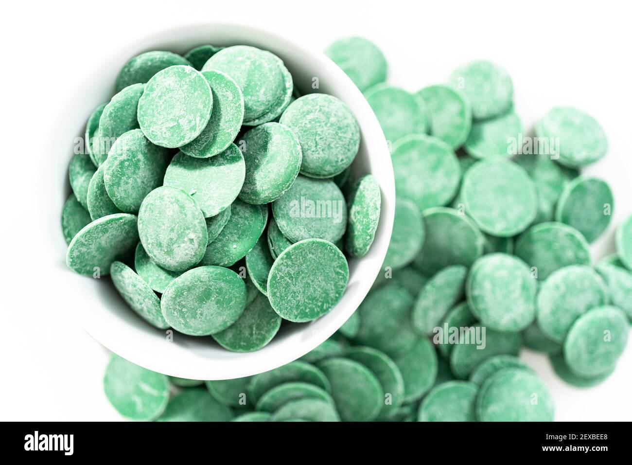 Green round chocolate chips for melting chocolate shapes on a white ...