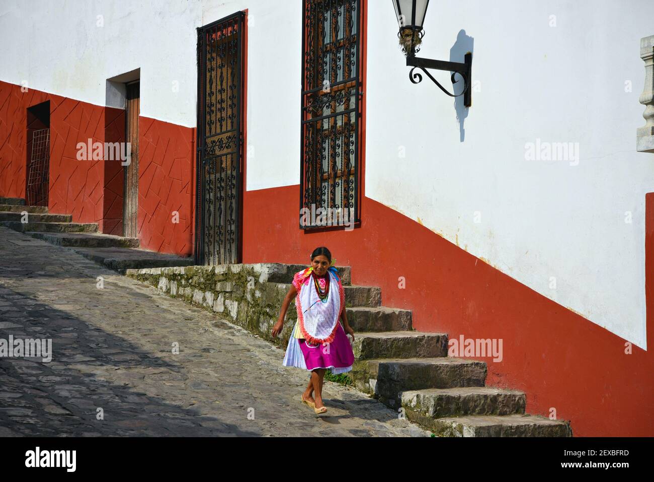 Indigenous Nahua woman walking on the narrow cobblestone streets with ...