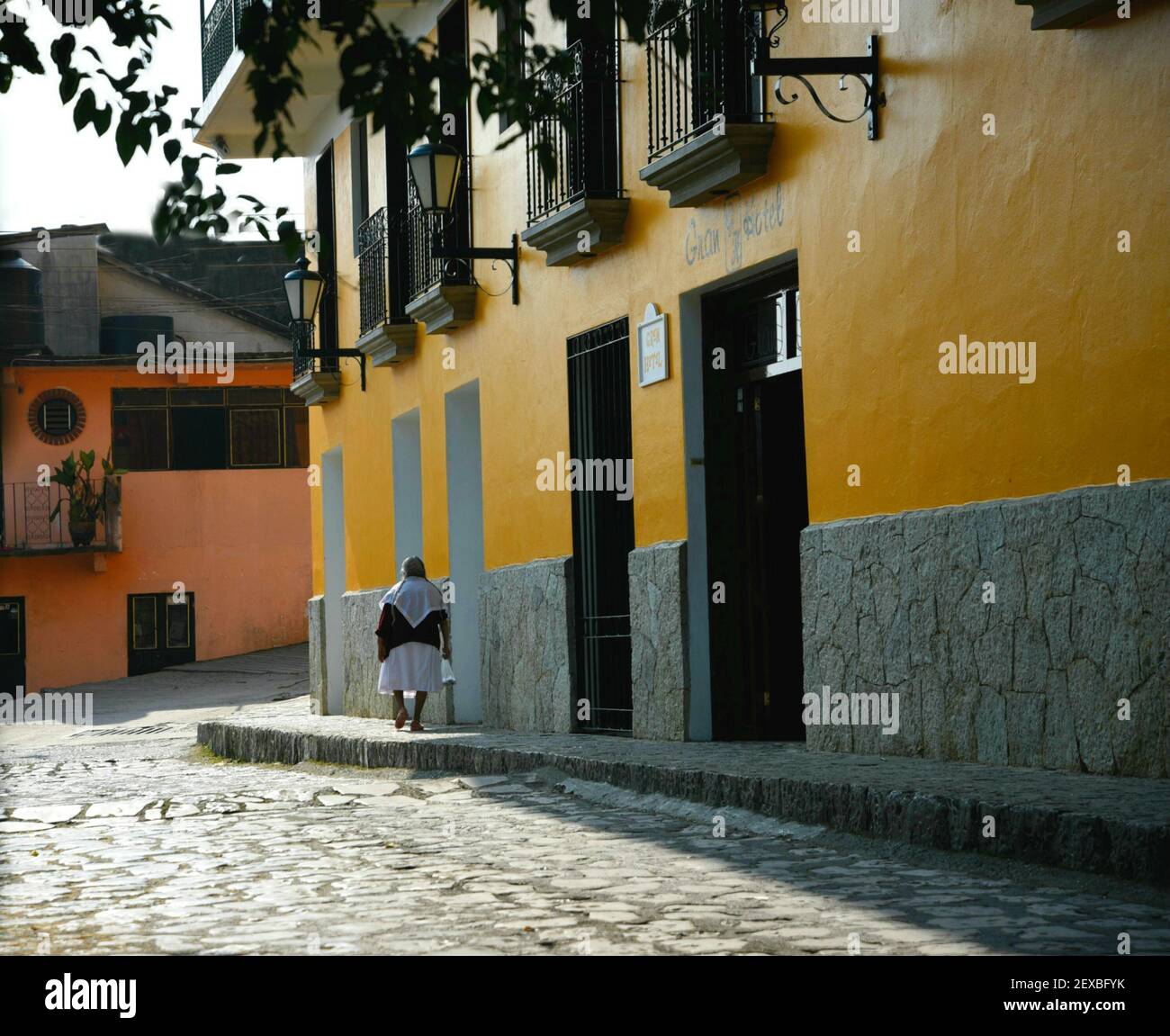 Indigenous Nahua woman walking on the narrow cobblestone streets with ...