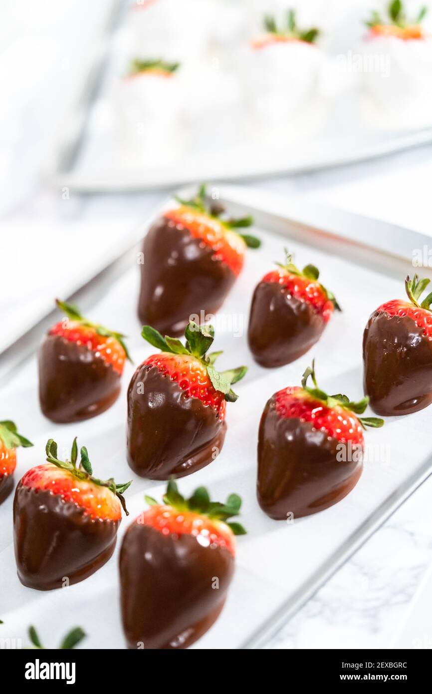 Making white and dark chocolate dipped strawberries Stock Photo - Alamy