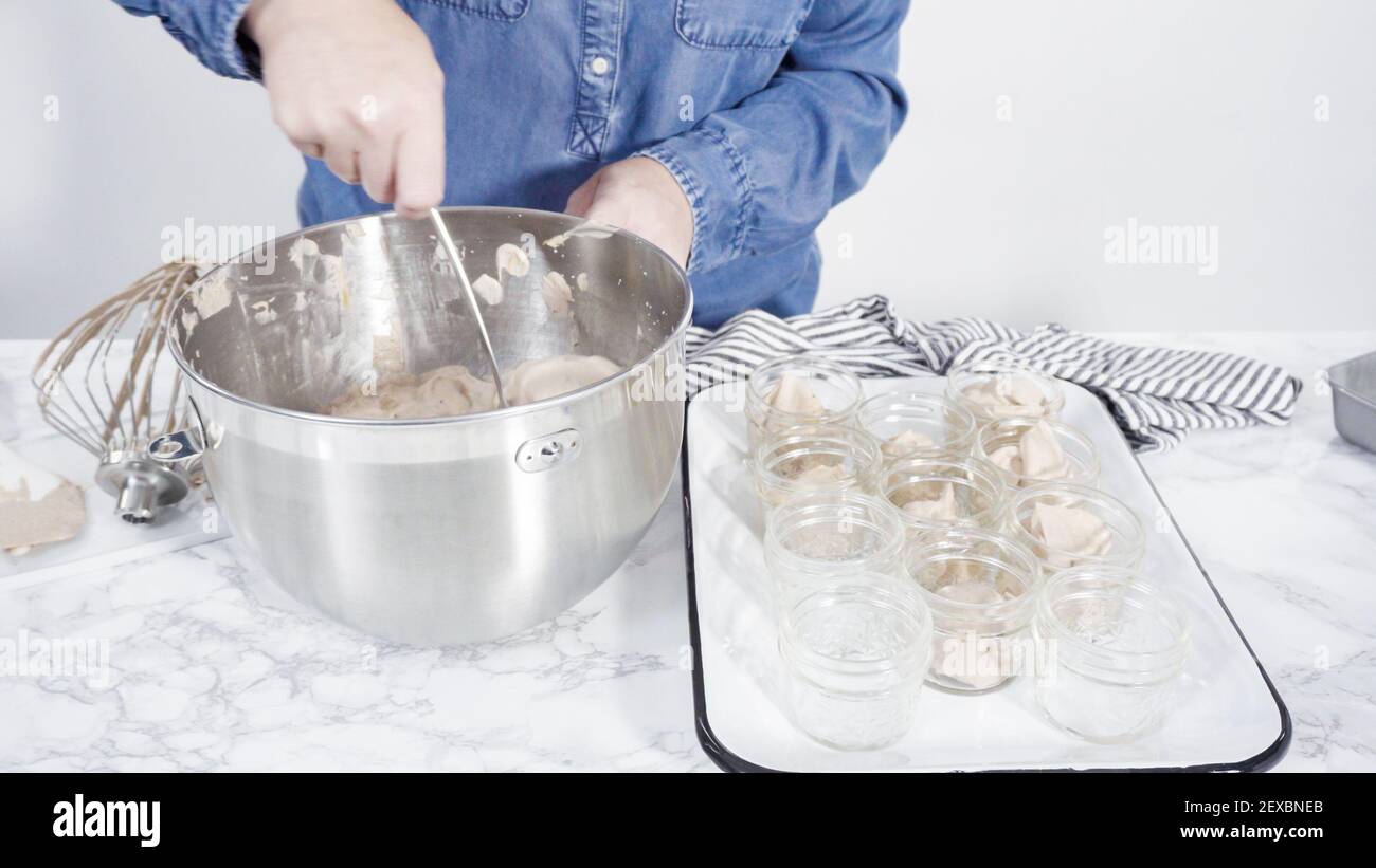 Step by step. Scooping homemade chocolate ice cream into glass jars ...
