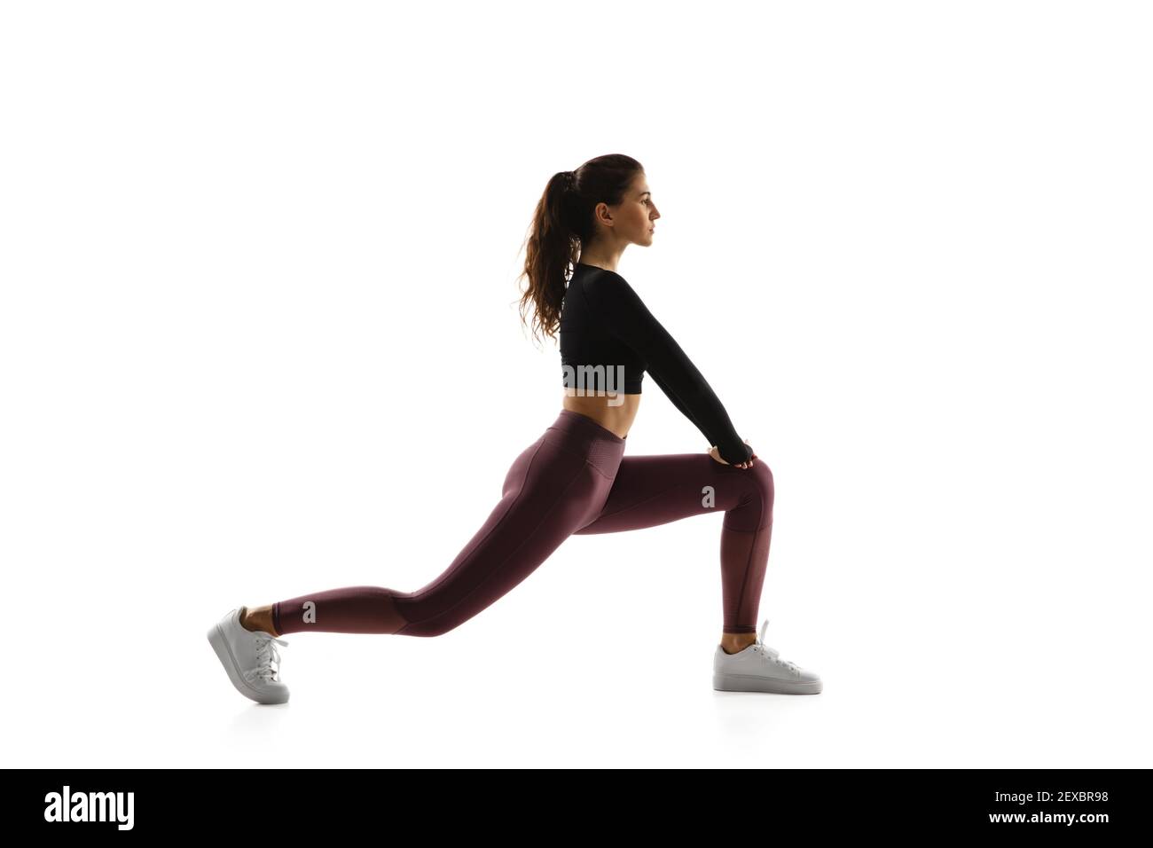 Squats. Young caucasian female model in action, motion isolated on ...