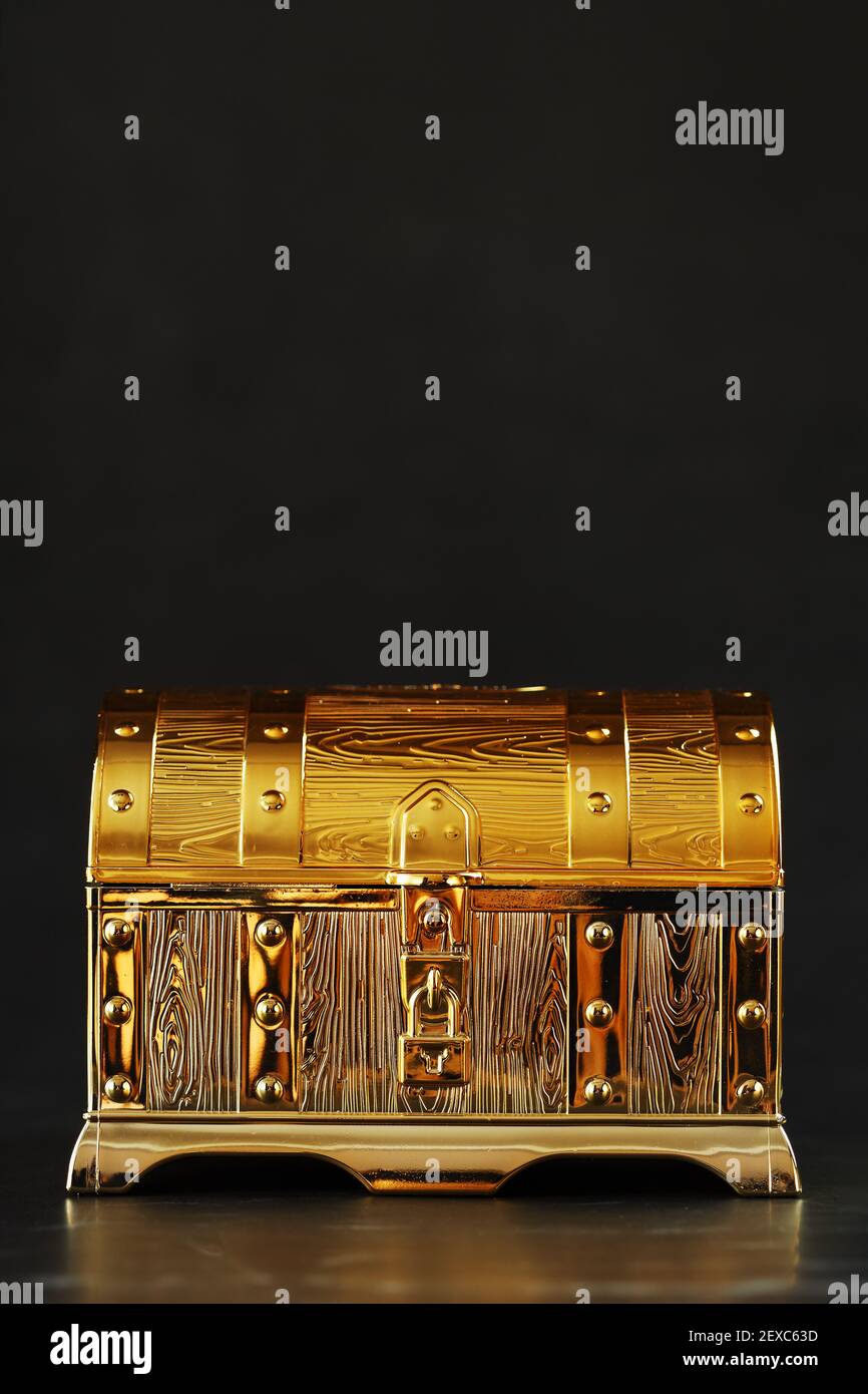 A chest made of gold with jewels on a black background. Free space, the ...