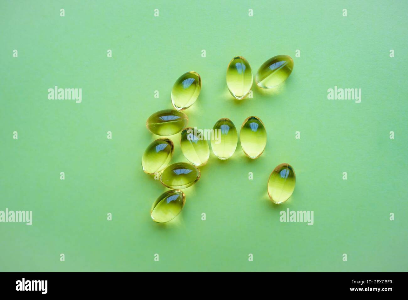 yellow capsules on a light green background Stock Photo - Alamy