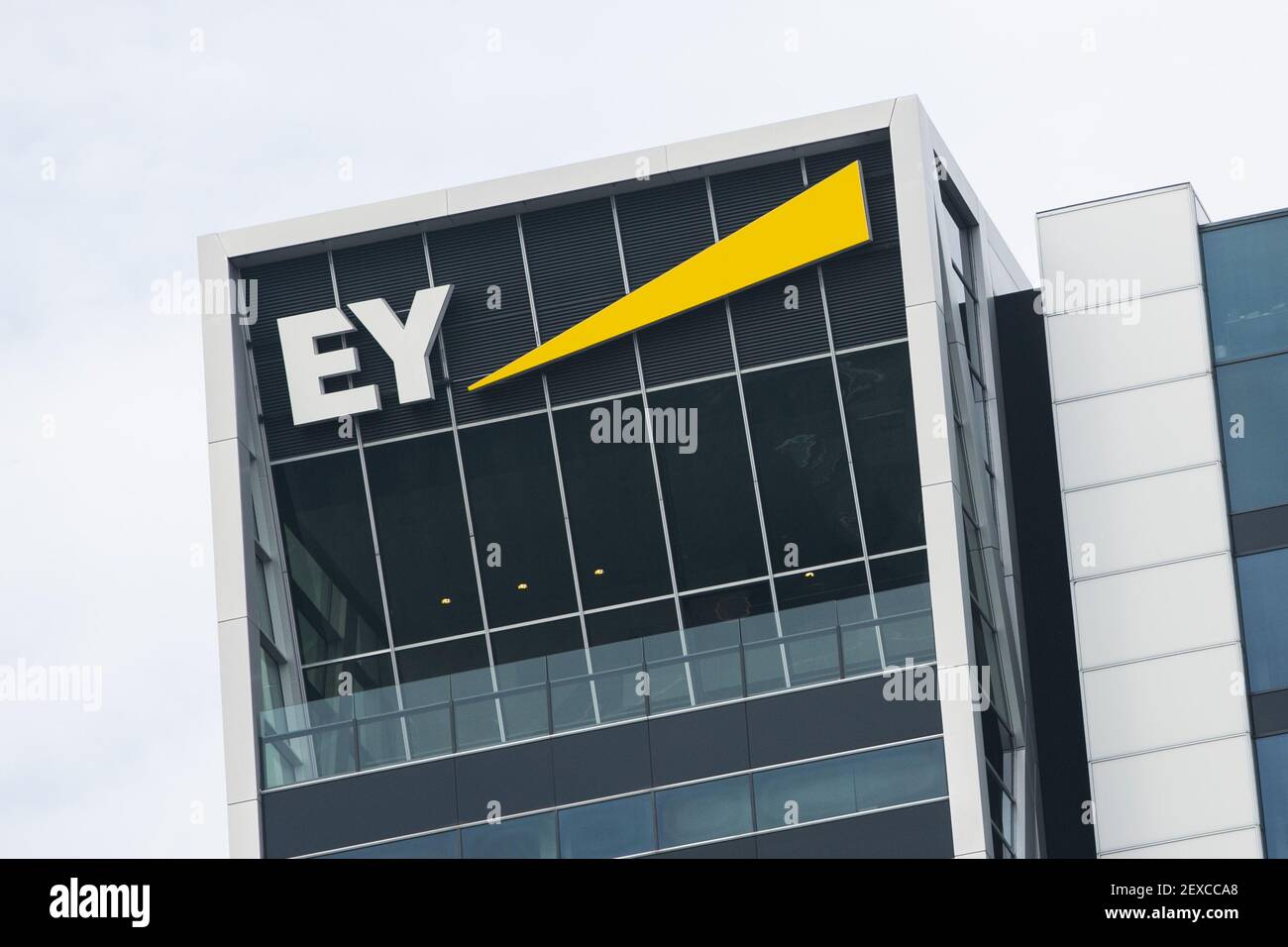 A logo sign outside of an office building occupied by Ernst & Young (EY ...