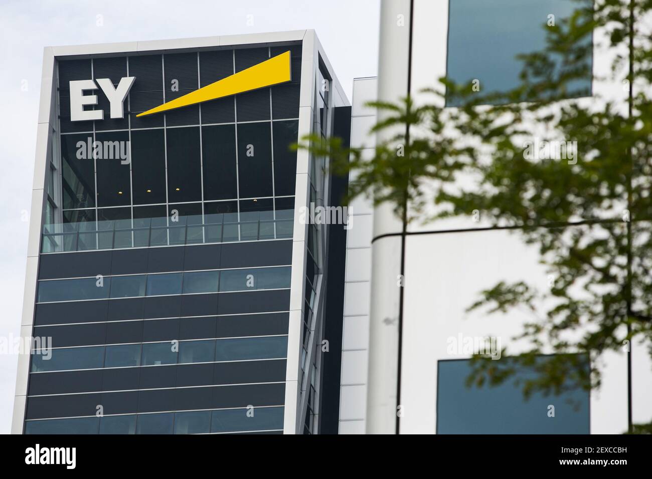 A logo sign outside of an office building occupied by Ernst & Young (EY ...