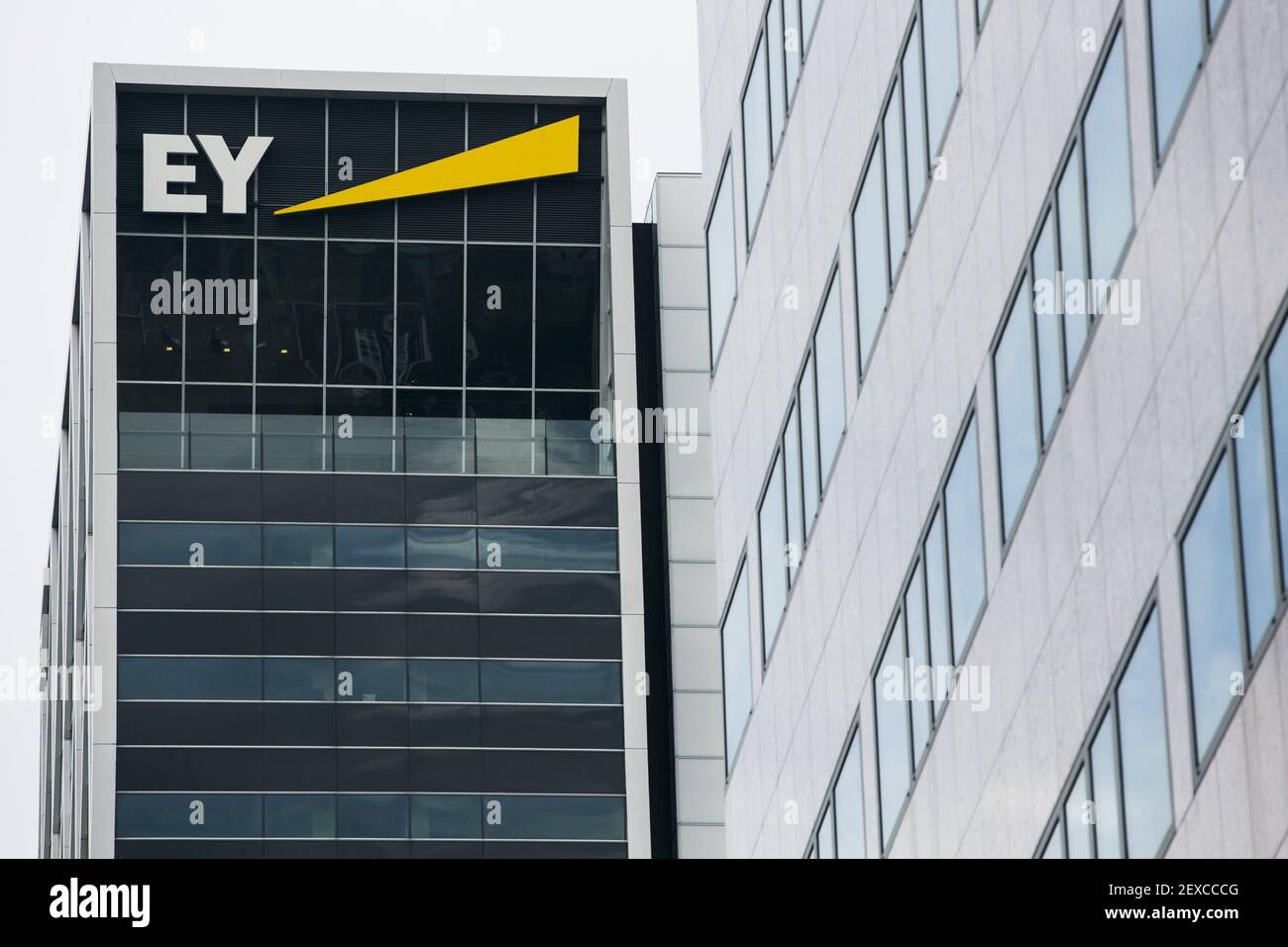A logo sign outside of an office building occupied by Ernst & Young (EY ...
