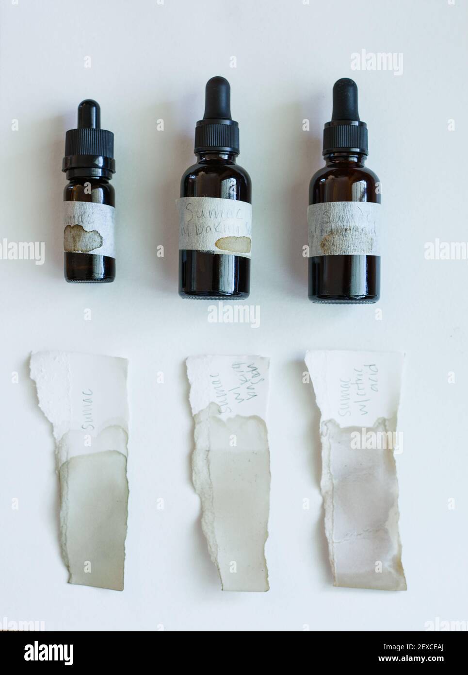 ink color samples in amber glass dropper bottles against a white ...